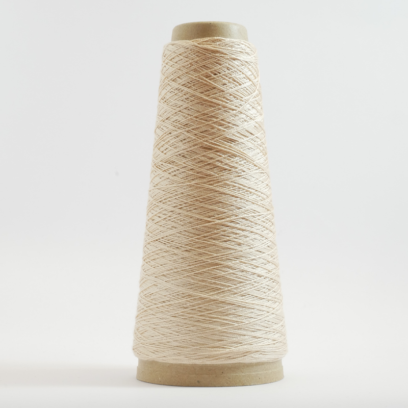 Machine knitting yarn on cones made from green tea. | Knit Works London